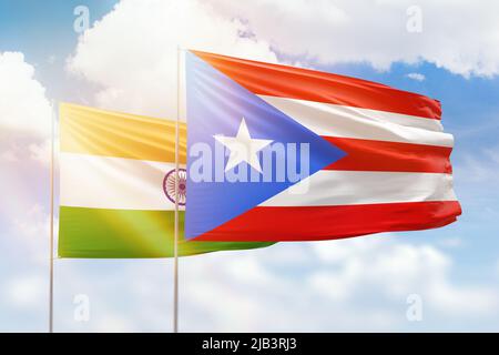 India and Puerto Rico flags waving together on blue cloudy sky, two ...