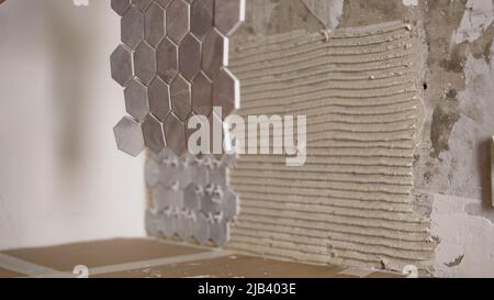 The process of applying plaster adhesive for ceramic tiles. The tile is ...