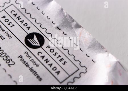A Canada Post postage paid stamp on a letter photographed against a ...
