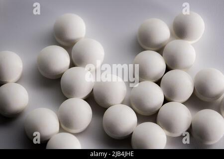 Close up of disk-shaped medical tablets (pills) in monochrome colour ...
