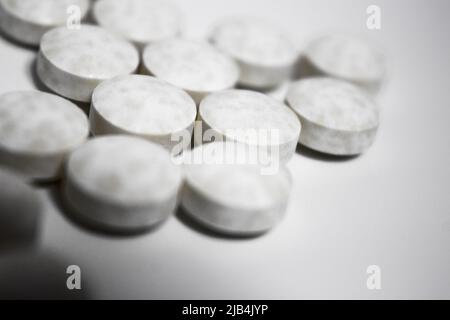 Close up of disk-shaped medical tablets (pills) in monochrome colour ...