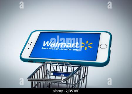 Walmart Logo on iPhone in a shopping cart. Walmart Inc. is an US retail ...