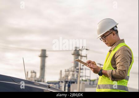 Oil refinery plant. Operation control room (center). Operator in red ...
