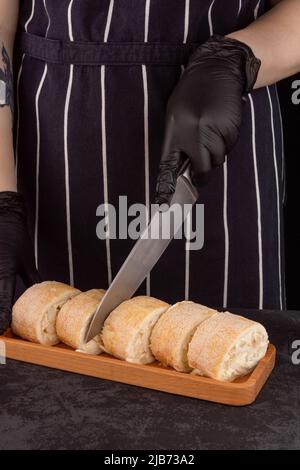 Baked meringue roll with cream and fresh fruits on a white wooden board ...