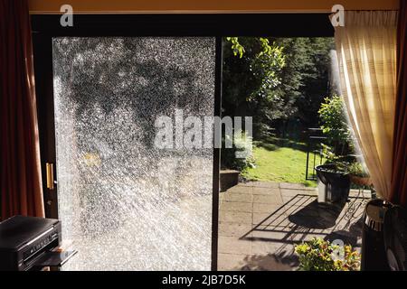 Smashed crazed broken glass double glazed window Stock Photo - Alamy