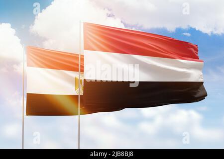 Egypt and Yemen flags waving together on blue cloudy sky, two country ...