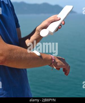 Using sunscreen cream on arm against sea under sunlight Stock Photo - Alamy