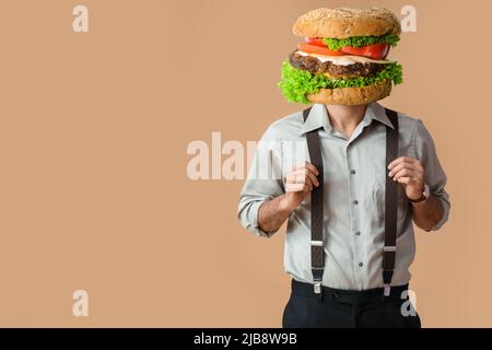 Man with tasty burger instead of his head on green background Stock ...