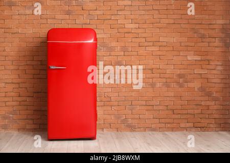 Stylish retro fridge near brick wall in room Stock Photo - Alamy