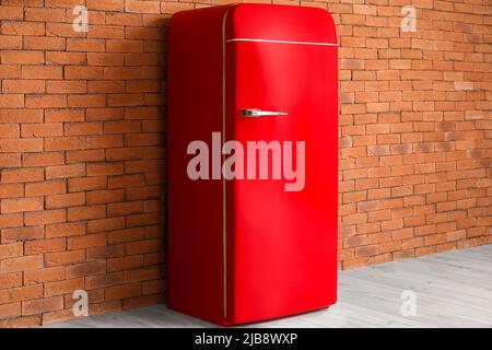 Stylish retro fridge near brick wall in room Stock Photo - Alamy