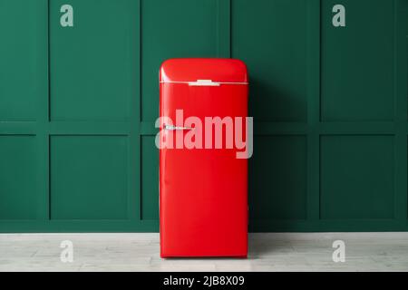 Stylish retro fridge near green wall in room Stock Photo - Alamy