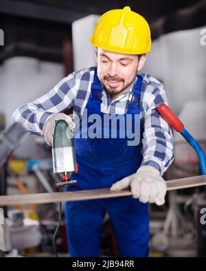 Working man practicing with power jigsaw Stock Photo - Alamy