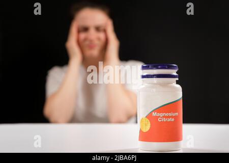 A tired woman and a jar of magnesium citrate. Dietary supplements for ...