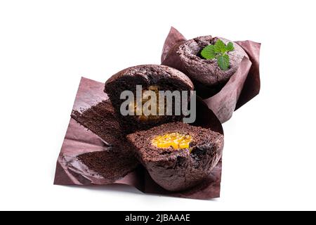 Dark chocolate muffin stuffed with yellow jam and cup of coffee on gray ...