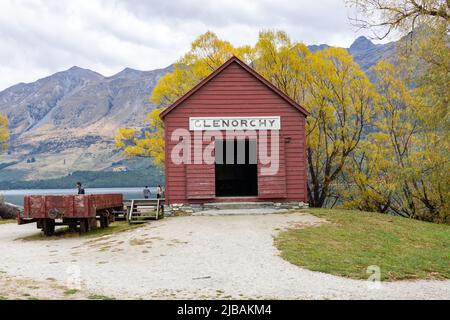 Historic red railway shed at Glenorchy with mountain and golden fall ...