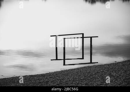 Steel structures standing in the shallow water, reflected in the ...