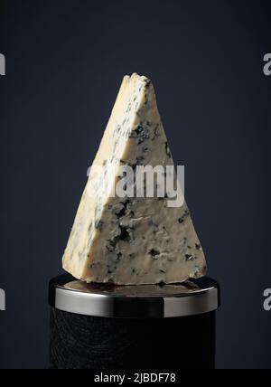 Triangle piece of blue cheese on a black background Stock Photo - Alamy