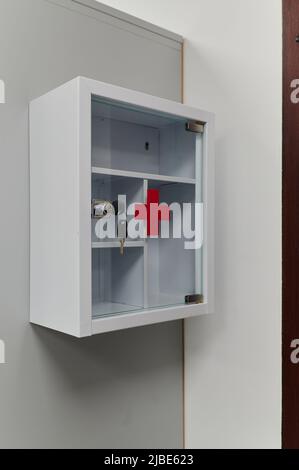 red first aid kit mounted to the wall full of supplies. red first aid ...