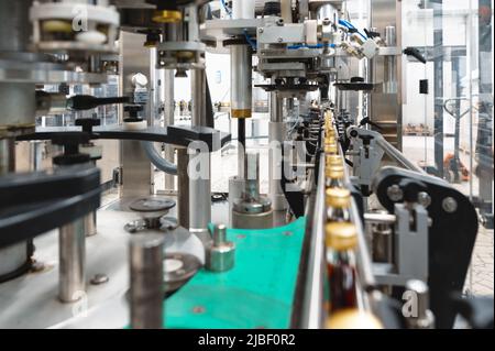 Production line transports closed bottles of yellow alcohol Stock Photo ...