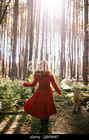 Back view of unrecognizable redhead female with outerwear standing ...