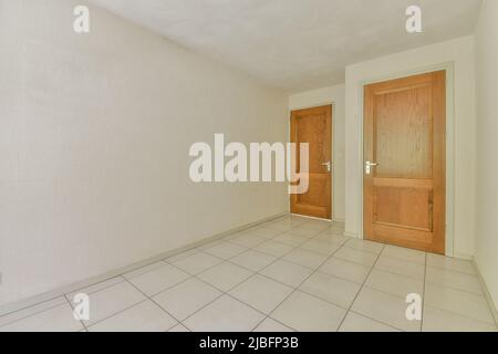 Interior of spacious empty room with tiled floor with wooden doors and ...