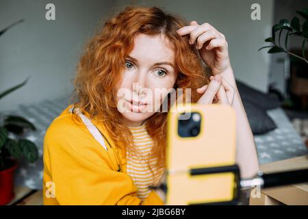 Red haired woman blogger broadcasts live reviews of beauty products for ...