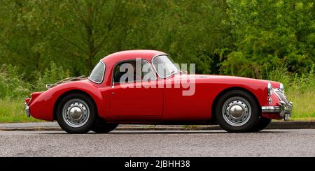 Classic red MG MGA sports car parked roadside in suburban British ...
