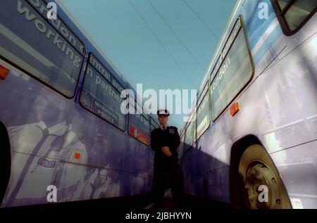 Mobile London Met Police bus with police officers standing to attention ...