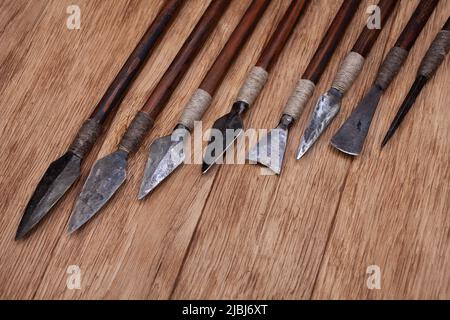 Different types of arrowheads made of iron on wooden background Stock ...