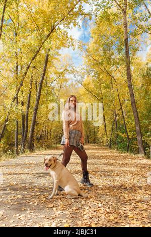 Young beautigul caucasian woman walking with her beloved labrador dog ...