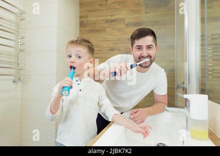 Morning at home, dad with children. Sons wash, brush teeth together in ...