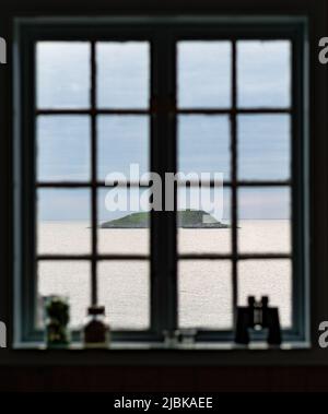View with ocean, a island and the horison, seen through an old window ...