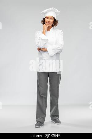Smiling young chef deciding on best fruits in grocery shop Stock Photo ...