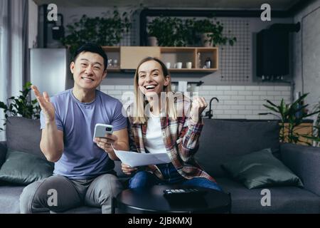 homework paper, multiracial couple, man and woman, pay bills by phone ...