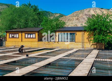 Dagestan, Russia - May 13, 2022: workers at a fish farm maintain ...