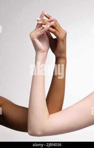 Plexus of female hands. Graceful female hands touch each other isolated ...