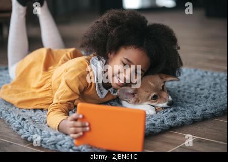 A pretty smiling girl with a puppy making selfie on her device Stock ...