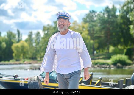 A bearded man in a captains cap looking contented Stock Photo - Alamy