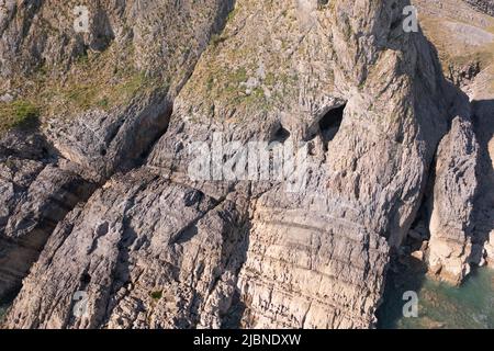 Aerial view of Paviland Cave, Goat;s Hole, South Gower cliffs, Wales ...
