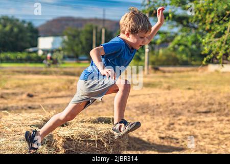 Kids jumping on hay bales at a pumpkin farm Stock Photo - Alamy