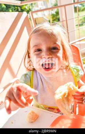 Child eating yogurt sitting on sofa one little boy eats yogurt with ...