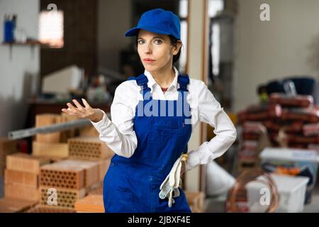 Woman construction worker posing inside house under renovation Stock ...