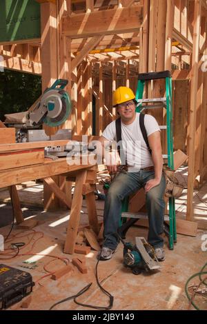 Latino man with a hat leaning on a wall playing the trumpet: Selective ...