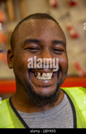 Smiling african ethnicity man wearing a sports tank top, standing with ...