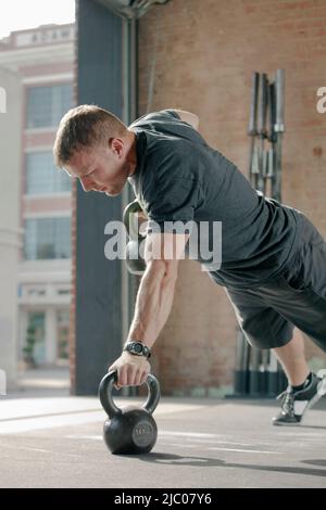 Young Man Exercising With Kettle Bell And Flexing Muscles - Muscular ...