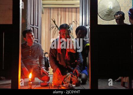 A witch doctor conducting a ritual on the porch of Dayak Iban's ...