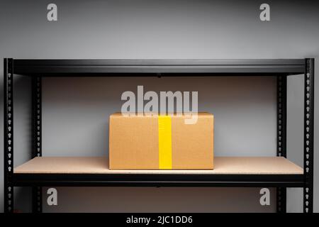 Stand shelf with one packed cardboard box Stock Photo - Alamy