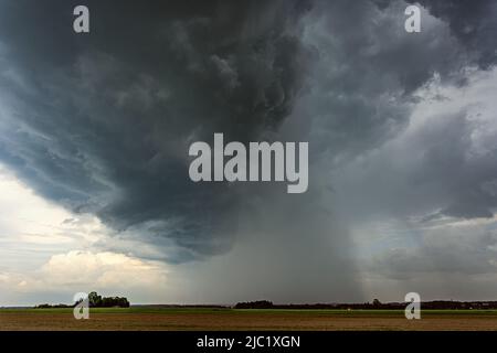 Storm clouds over field, downburst of rain, dangerous storm Stock Photo ...