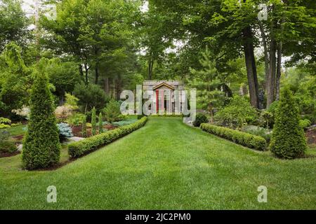 Reading pavilion in landscaped residential backyard garden in summer ...