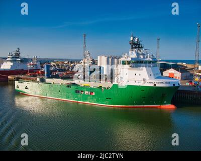 Offshore supply vessel moored at industrial port terminal with yellow ...
